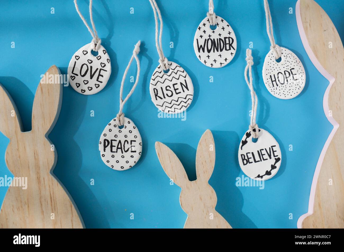 Group of wooden bunny ears and clay Easter eggs with words RISEN HOPE ...