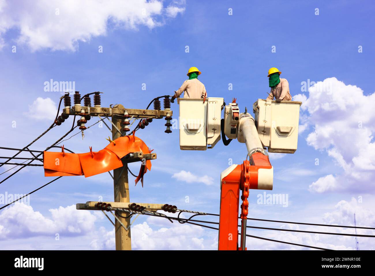 electric engineering team working on cradle of aerial platform or crane ...
