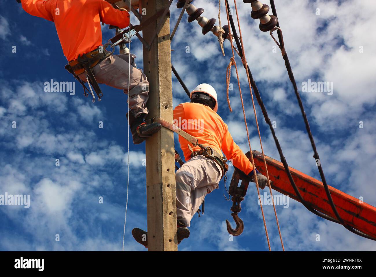 electric worker team changing high voltage transmission lines on pole ...
