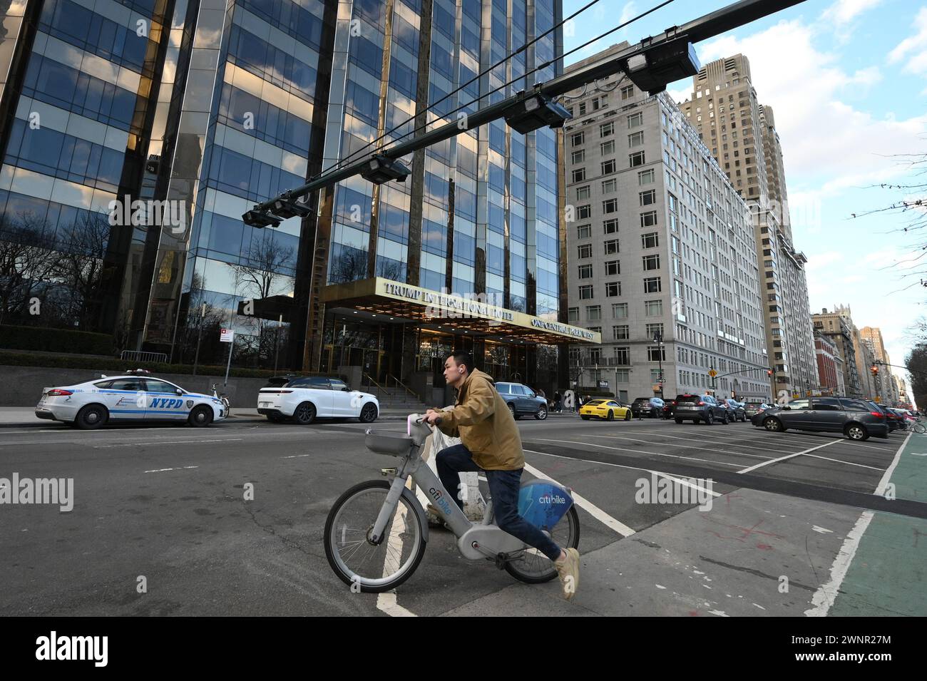 A man rides a city bicycle under a gantry supporting license plate and ...