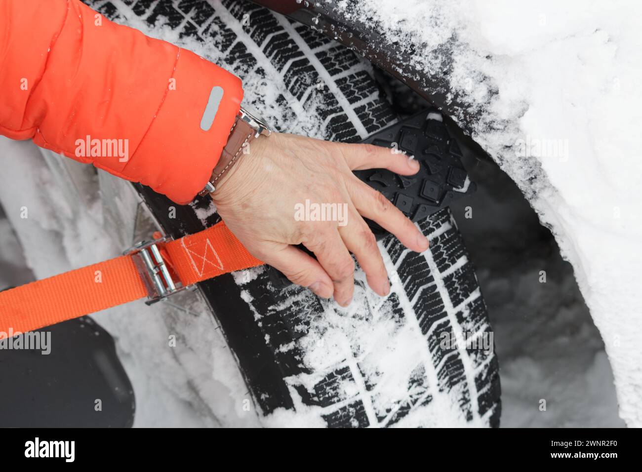 Japanese male attaching a temporary snow chain to a winter tyre Stock ...