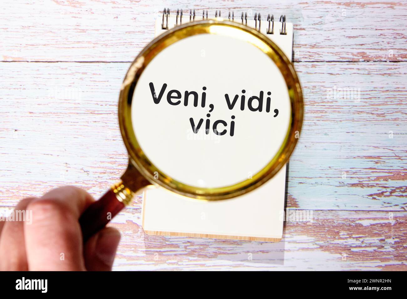 Latin Veni Vidi Vici (I came, I saw, I won) through a magnifying glass ...