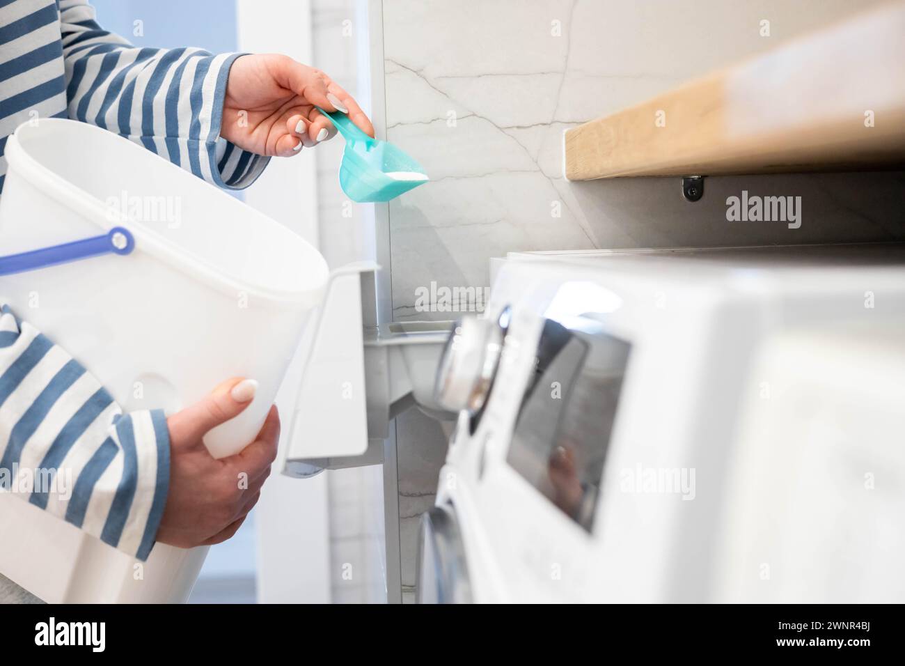 Woman housewife hands adding dry washing powder to washer machine ...