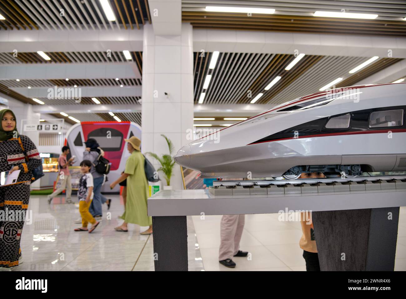 Jakarta, Indonesia. 3rd Mar, 2024. Passengers walk past a model of a high-speed electrical ...
