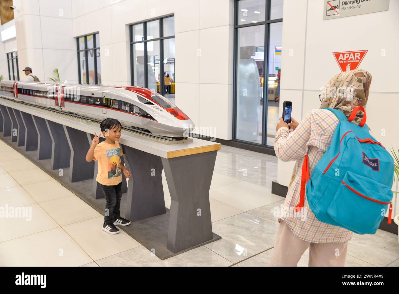 Jakarta, Indonesia. 3rd Mar, 2024. A boy poses for photos with a model of a high-speed ...