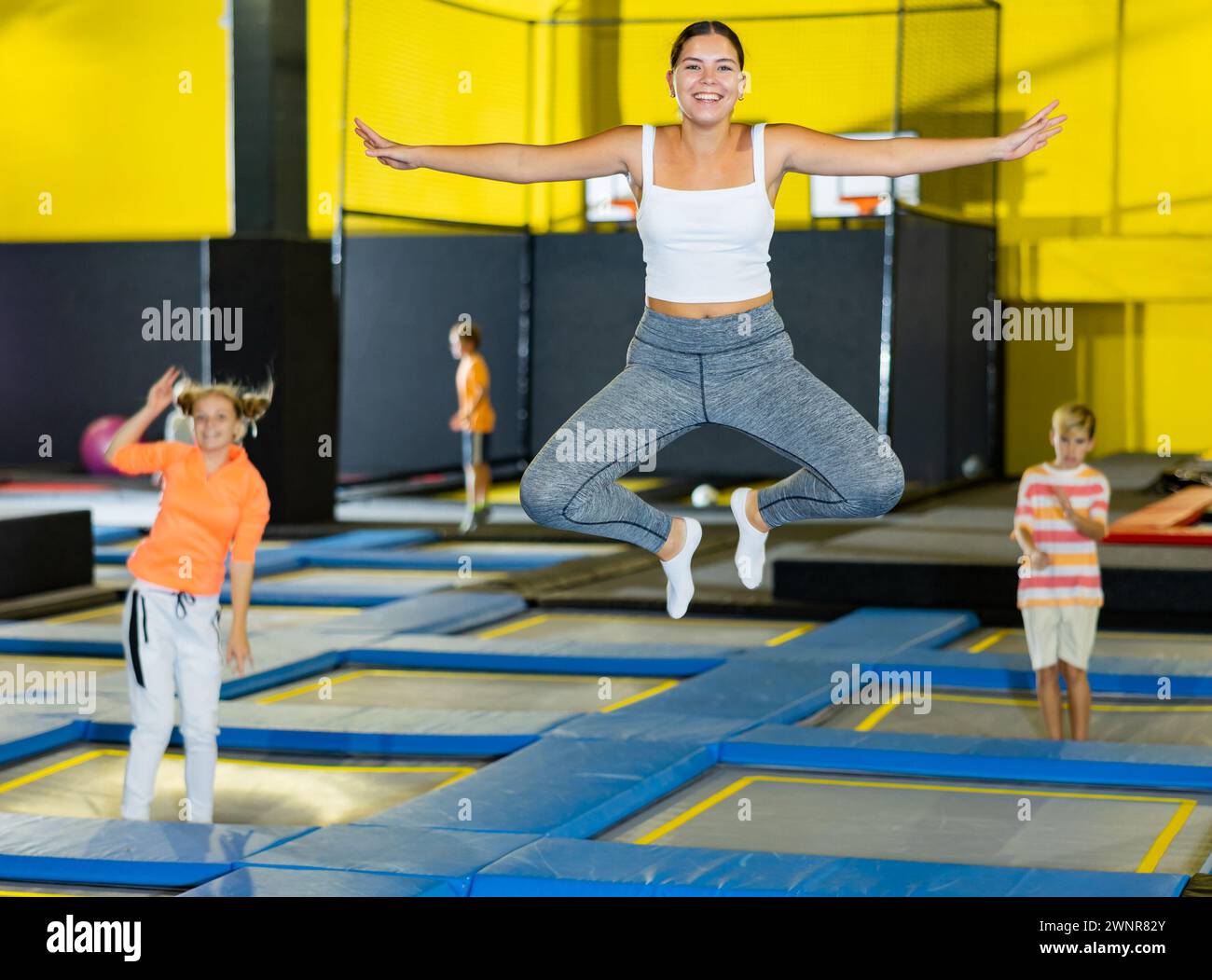 Cheerful young girl jumping in indoor trampoline arena Stock Photo - Alamy