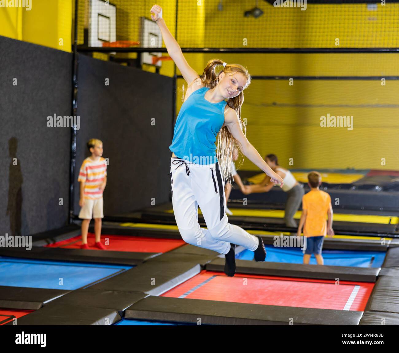 Happy teen girl in blue jersey and white pants jumping and indulging on ...