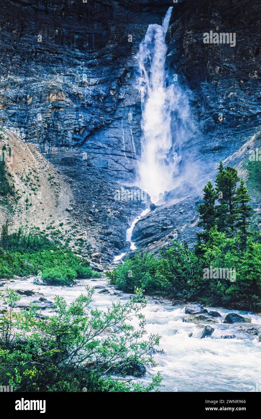 Riverbed by a mountain with a high waterfall Stock Photo - Alamy
