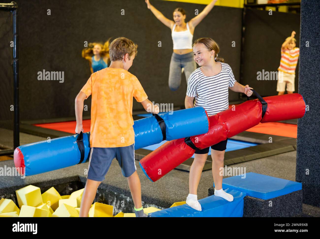 Tween girl having fun on battle beam with friend Stock Photo - Alamy