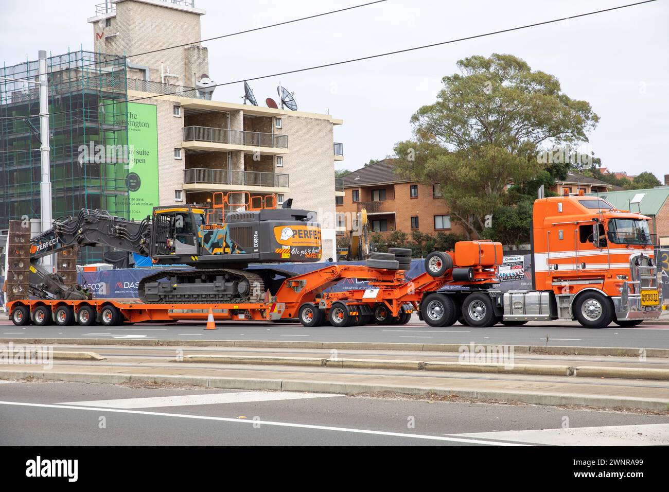 Oversize low loading vehicle transports a construction excavator digger ...