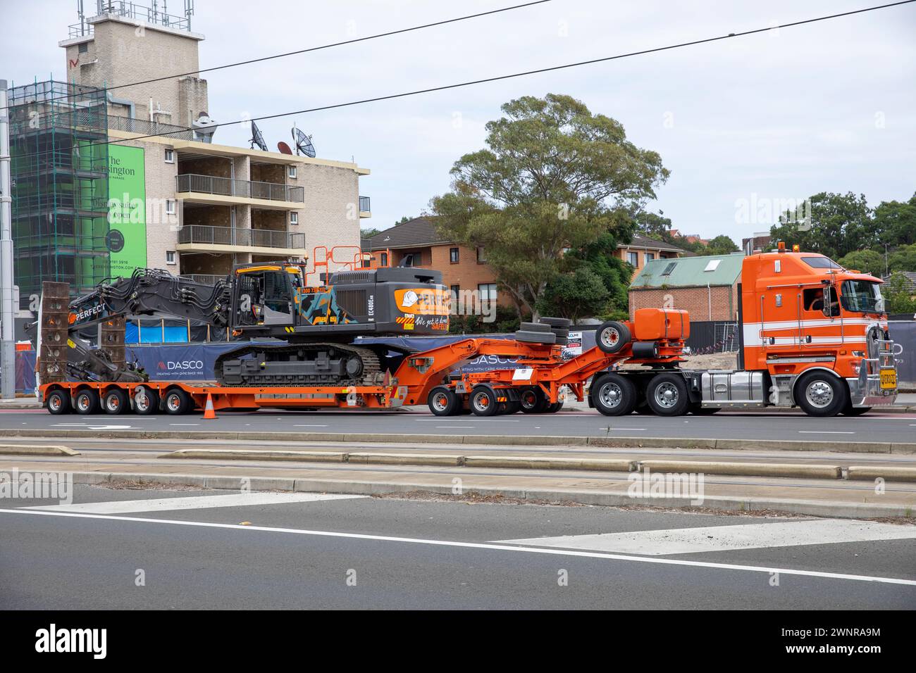 Oversize low loading vehicle transports a construction excavator digger ...