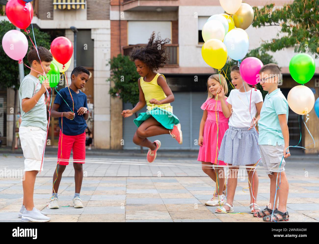 Kids playing with Chinese jumping rope outdoors Stock Photo - Alamy