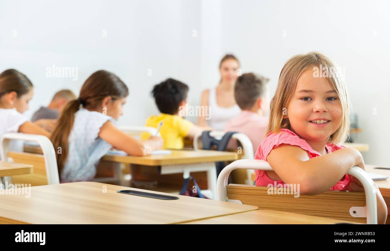 Schoolgirl sitting in classroom Stock Photo - Alamy