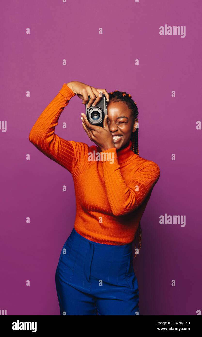Female photographer stands with confidence and a smile, capturing a fun ...