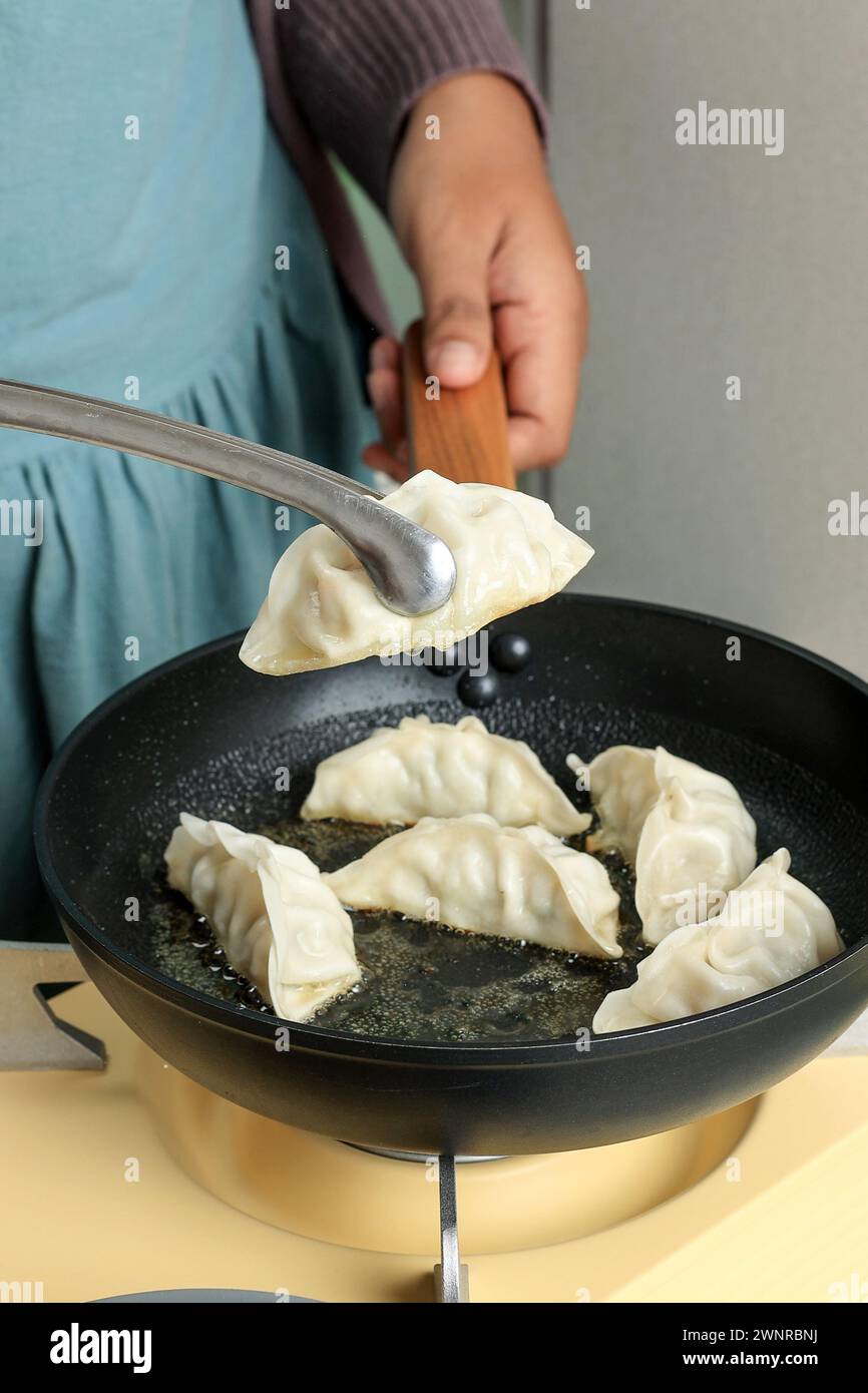 Cooking Gyoza Japanese Potsticker Dumpling on Black Pan, Female Hand ...