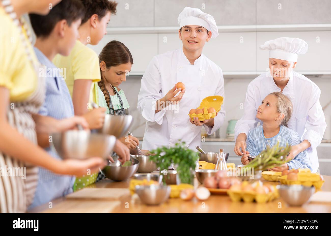 Two friendly chefs giving culinary lesson to group of tweens Stock ...