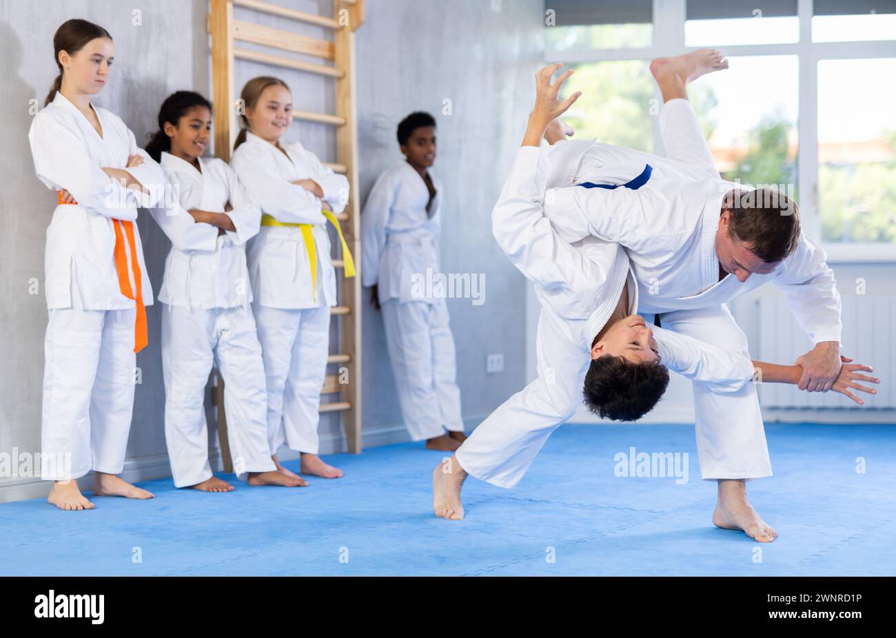 Martial arts master demonstrating throwing technique in sparring with ...