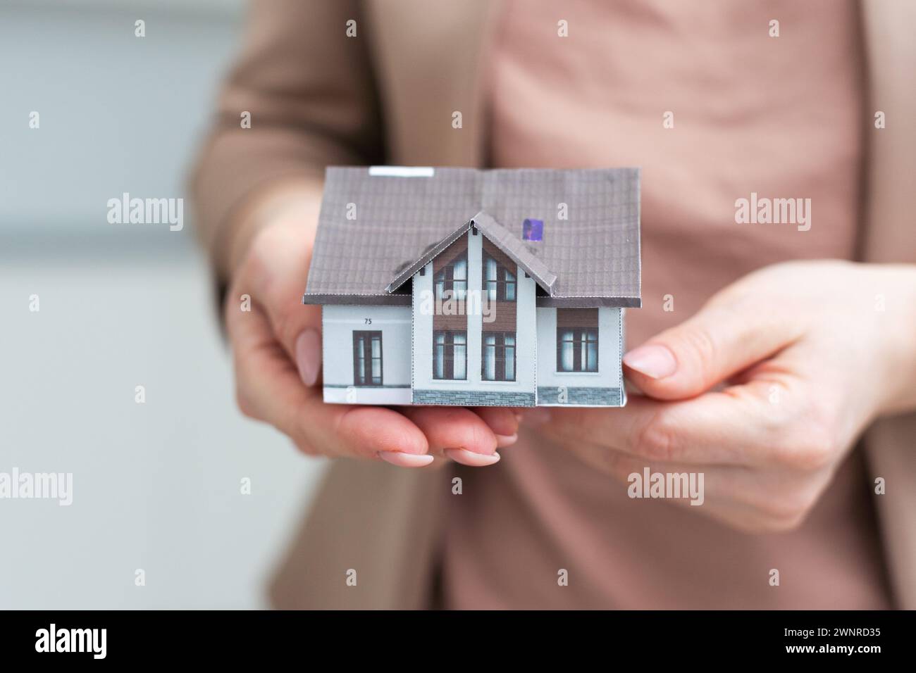 holding house representing home ownership and the Real Estate business ...