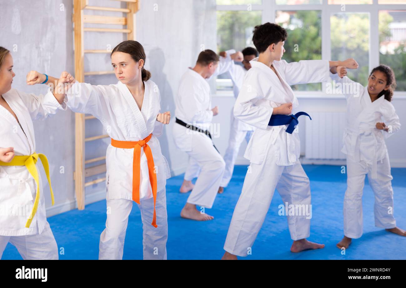 Two girls learn to throw punches and kicks in sparring for karate ...