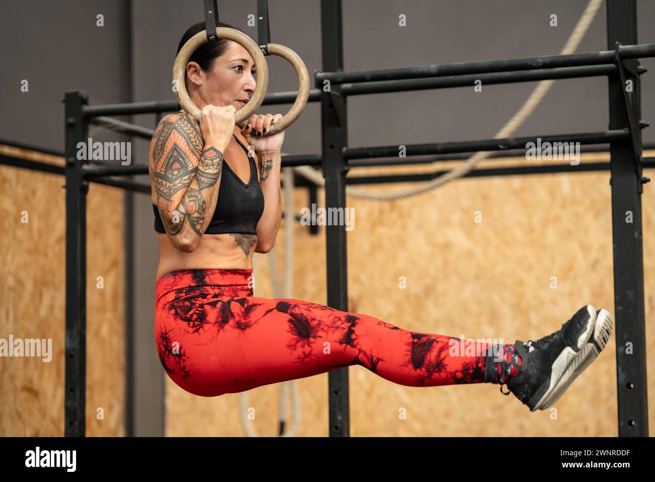 Strong mature woman hanging from olympic rings Stock Photo - Alamy