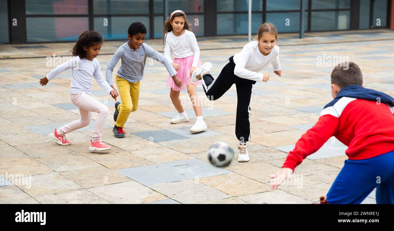 Group of happy schoolchildren playing football together Stock Photo - Alamy