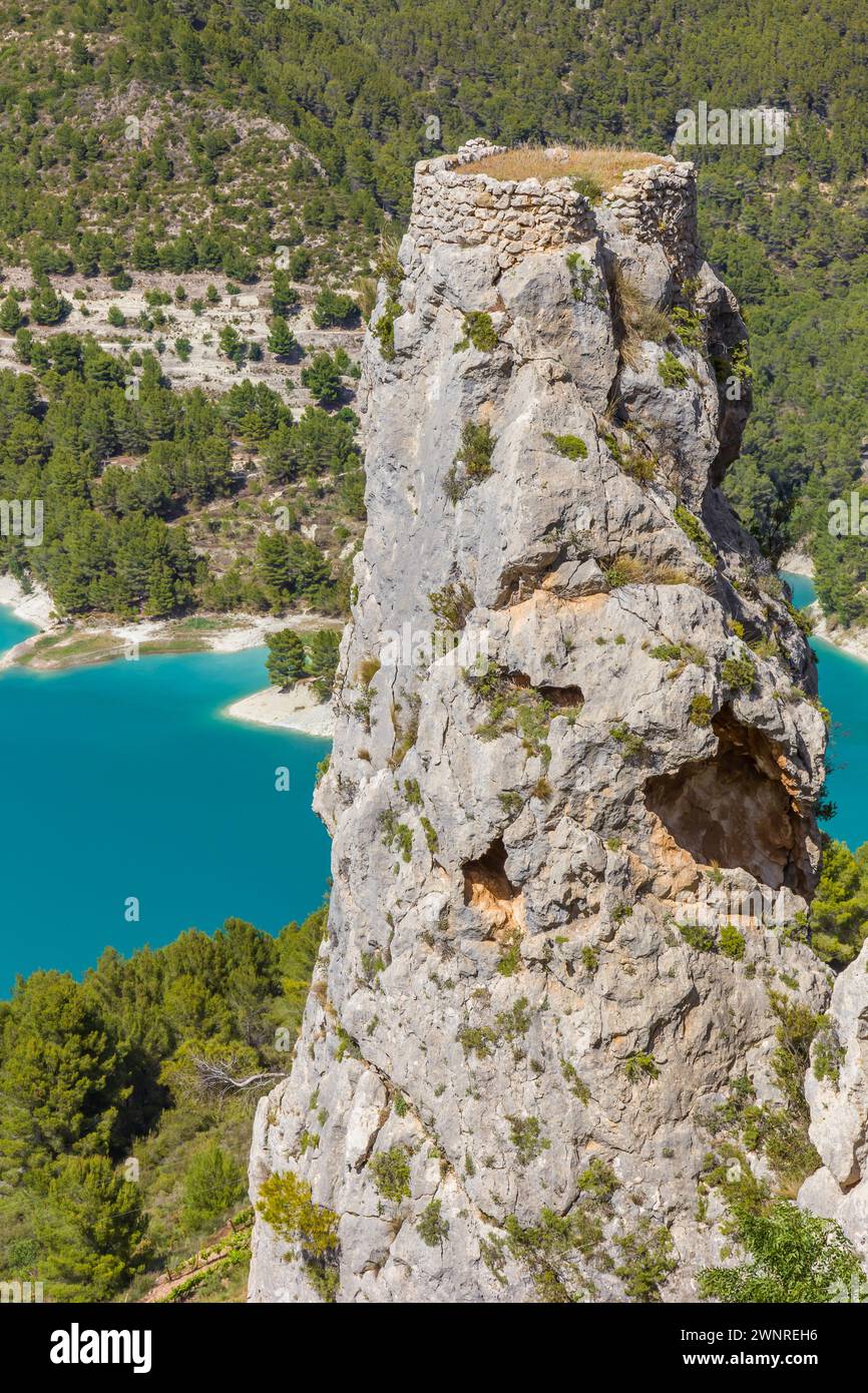 Ruins of a round castle tower above the blue lake in Guadalest, Spain ...