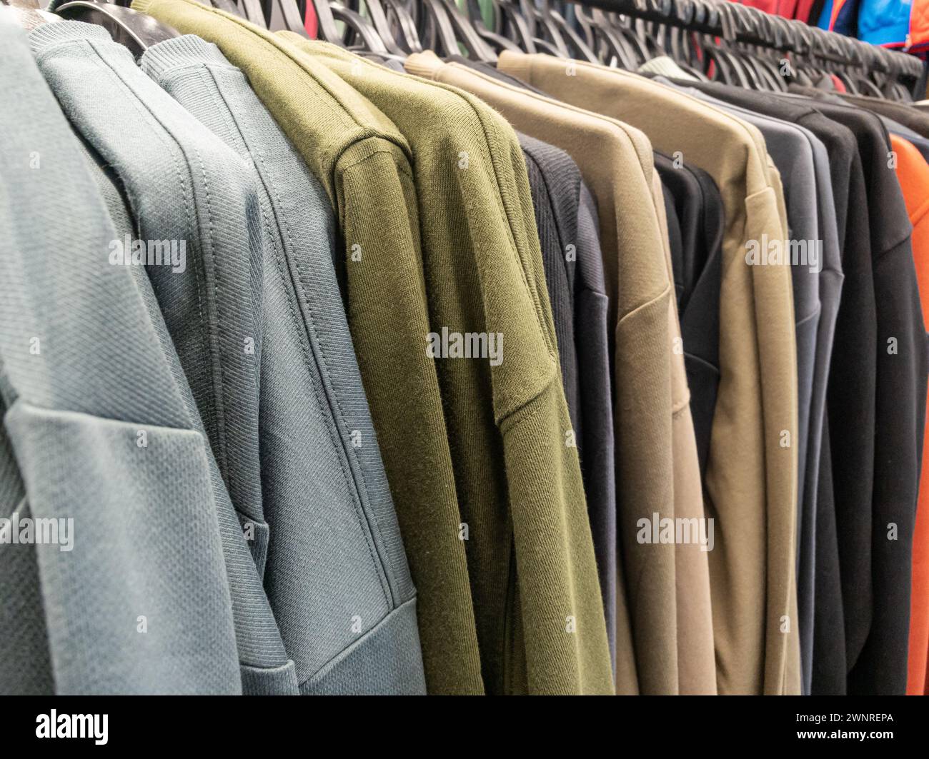 Rack of clothes with a variety of colors and styles. The clothes are ...