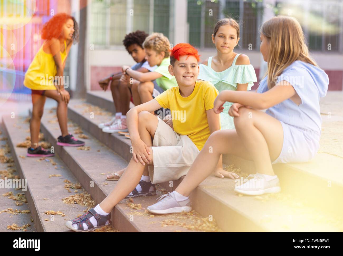 Group of kids sitting on stairs outdoors and talking Stock Photo - Alamy