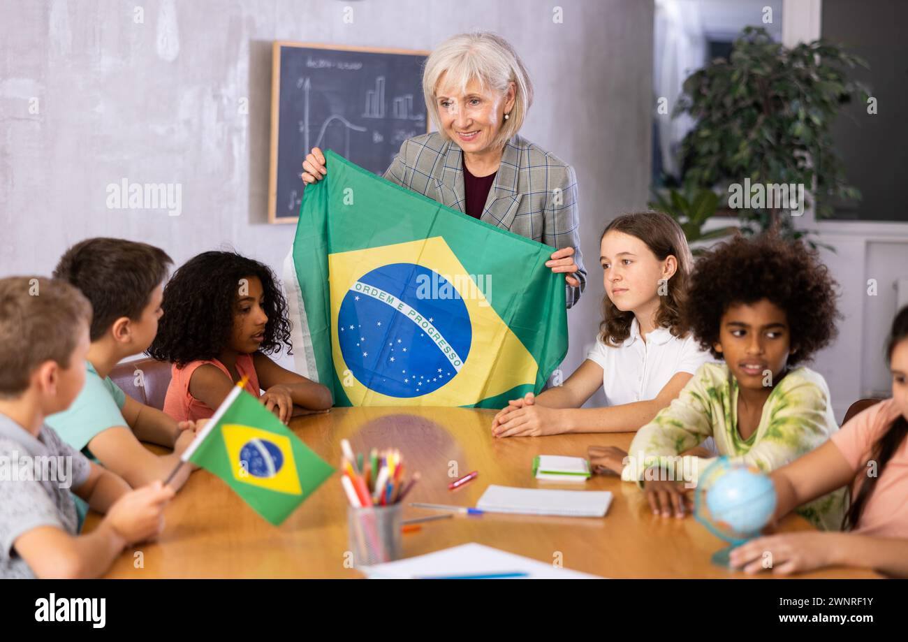 Female teacher showing brazilian flag to kids in geography class Stock ...