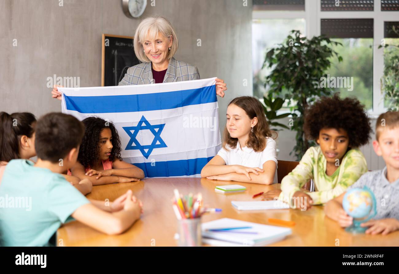 Mature woman teacher tells pupils the history of Israel Stock Photo - Alamy