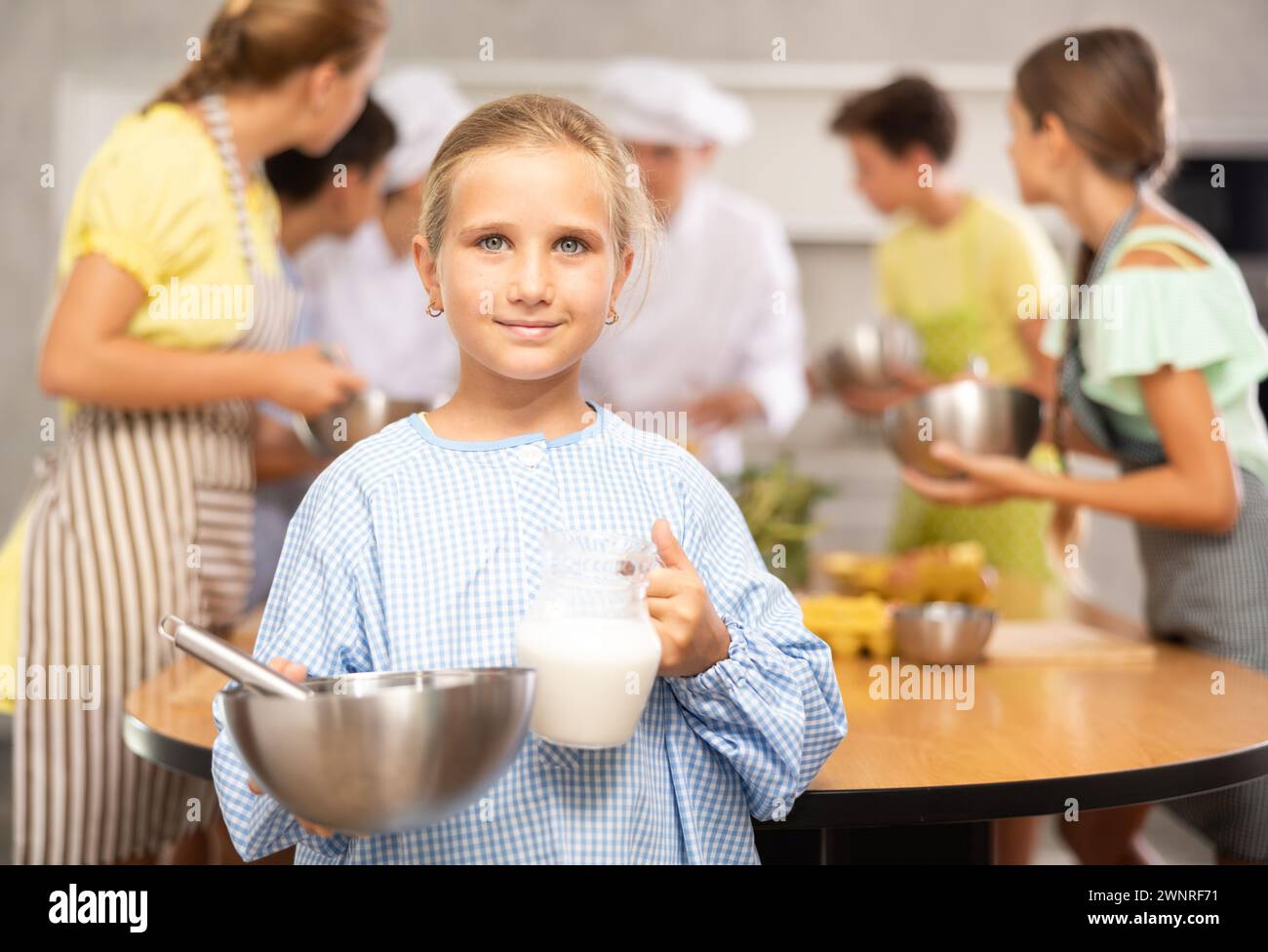 Interested tween girl attending group culinary classes for children ...