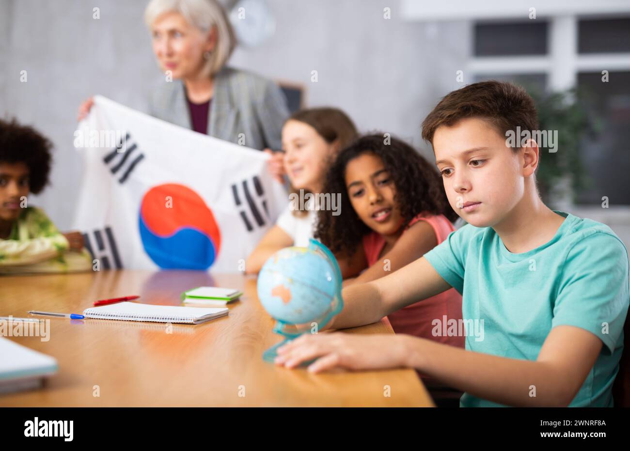 students listen to woman teacher who talks about South Korea Stock ...