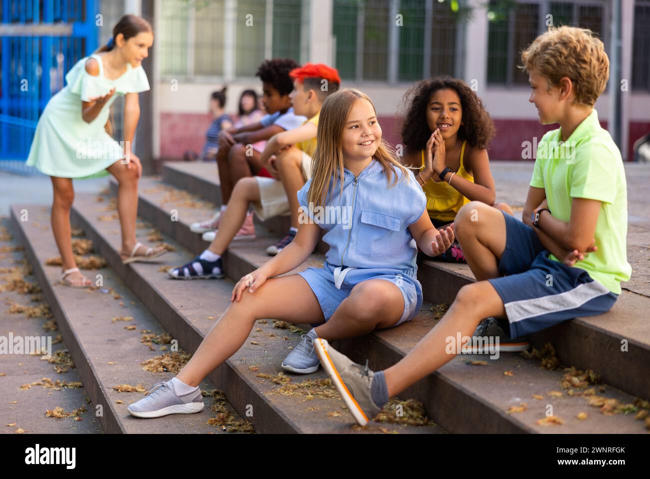 Group of kids sitting on stairs outdoors and talking Stock Photo - Alamy