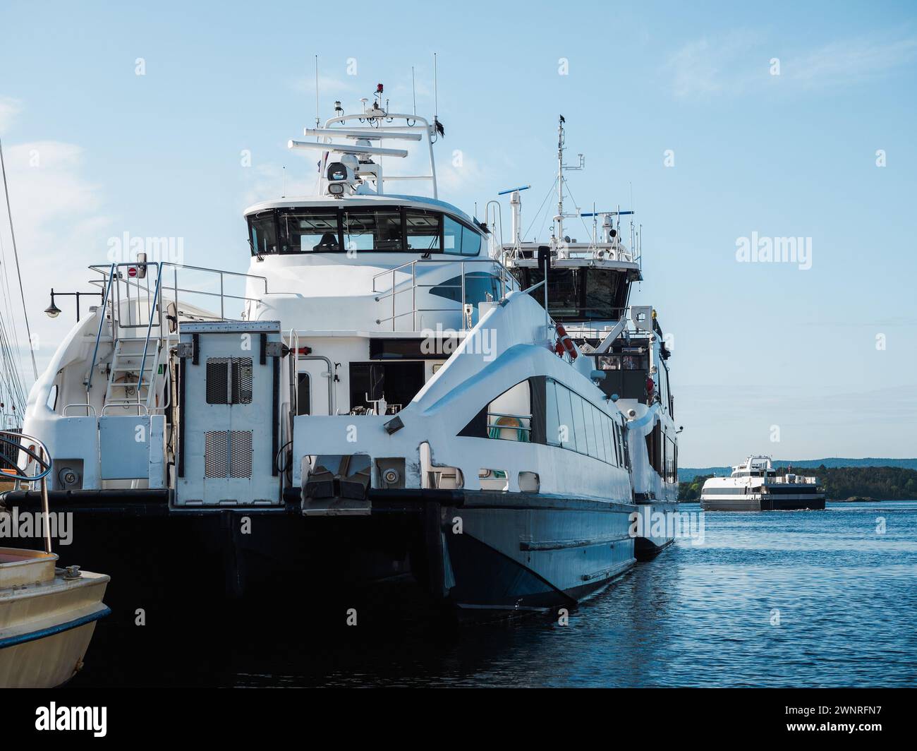 Modern ferry cruising in Oslo fjord and arriving to a city quayside ...