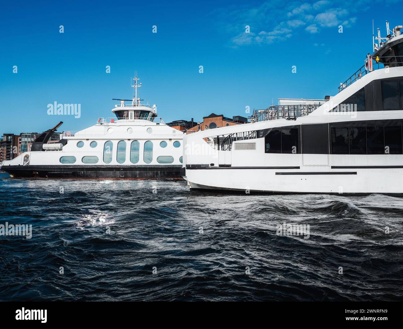 Modern ferry cruising in Oslo fjord and arriving to a city quayside ...