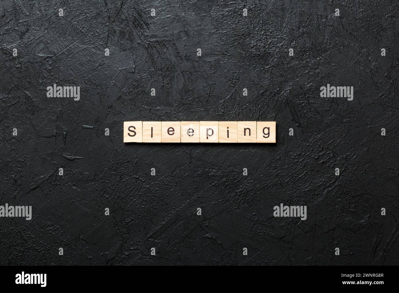 SLEEPING word written on wood block. SLEEPING text on cement table for ...