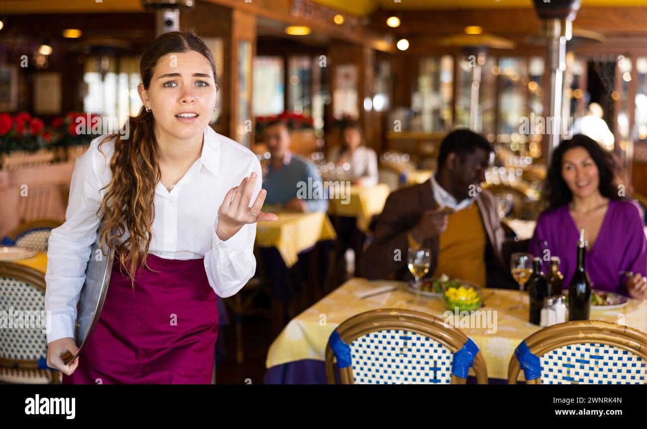 Stressed young waitress fed up with work standing in restaurant Stock ...