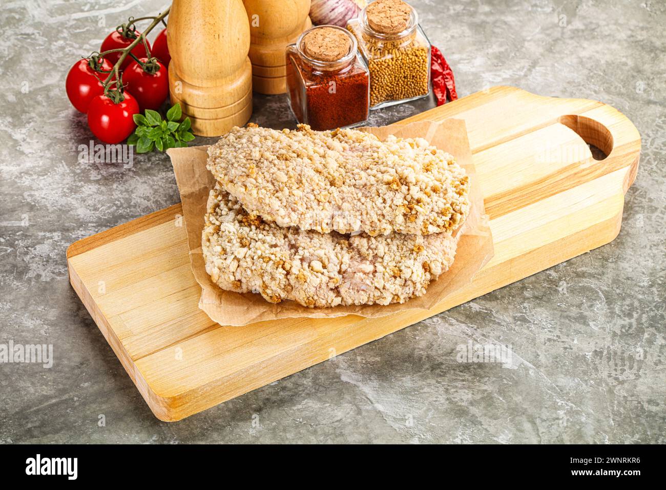 Breaded raw breaded meat schnitzel for roast Stock Photo - Alamy