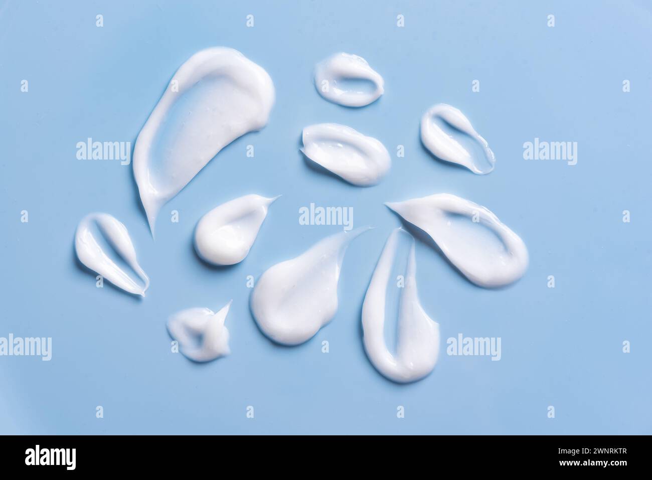 White cosmetic cream lotion swatch smear smudge pattern on blue ...