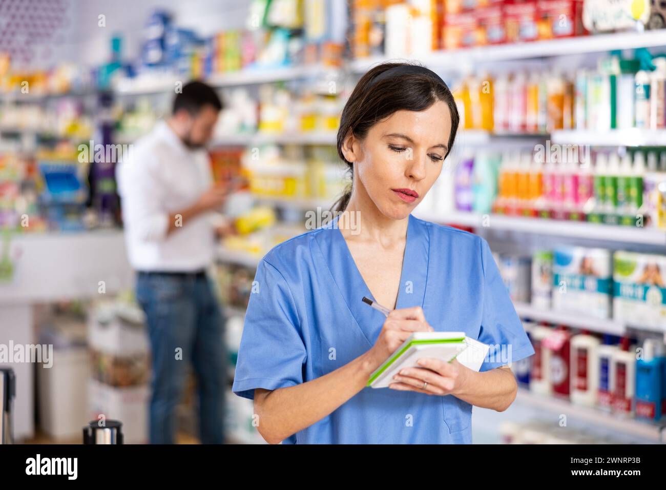 Female pharmacist checking assortment of drugs in pharmacy closeup ...
