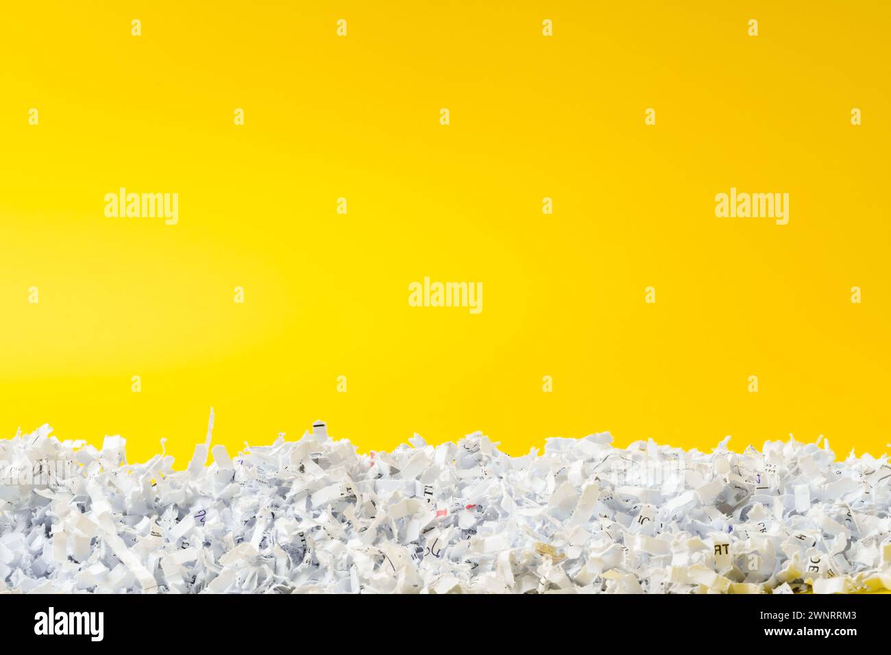 Shredded white paper on light yellow background Stock Photo - Alamy