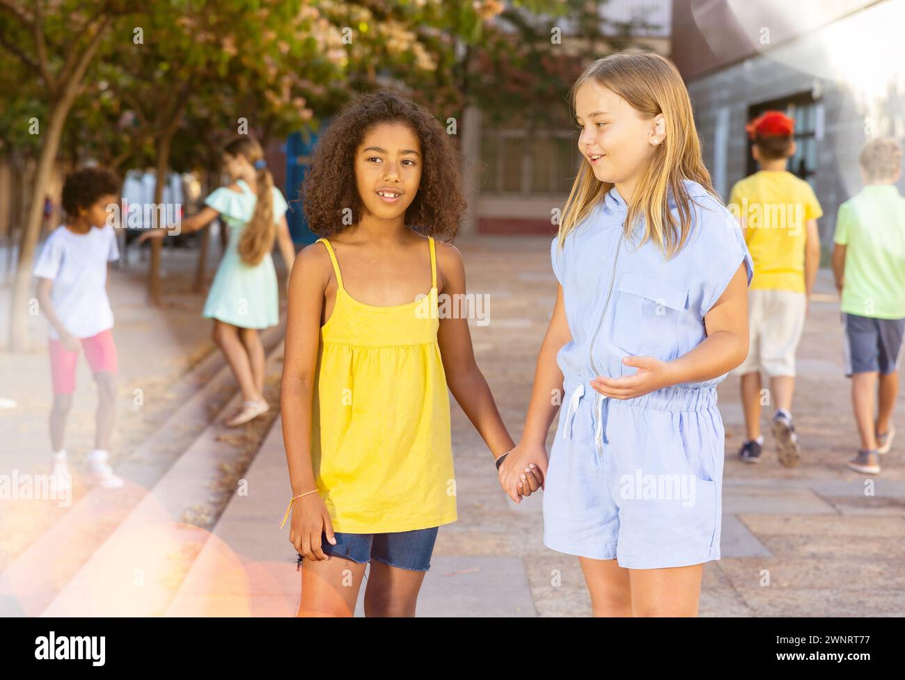 Two girls talking during walk Stock Photo - Alamy