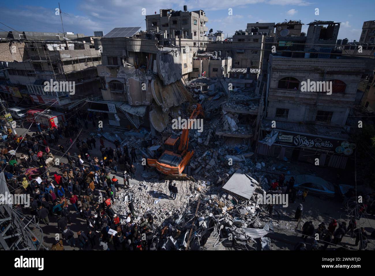 Palestinians search for bodies and survivors in the rubble of a ...