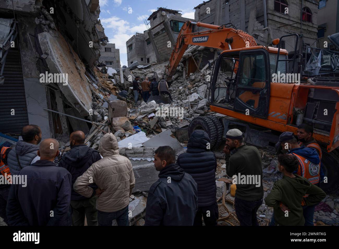 Palestinians search for bodies and survivors in the rubble of a ...