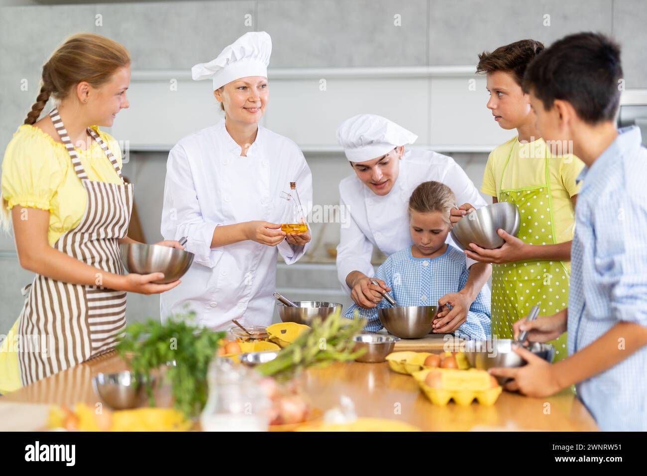 Two friendly chefs giving culinary lesson to group of tweens Stock ...