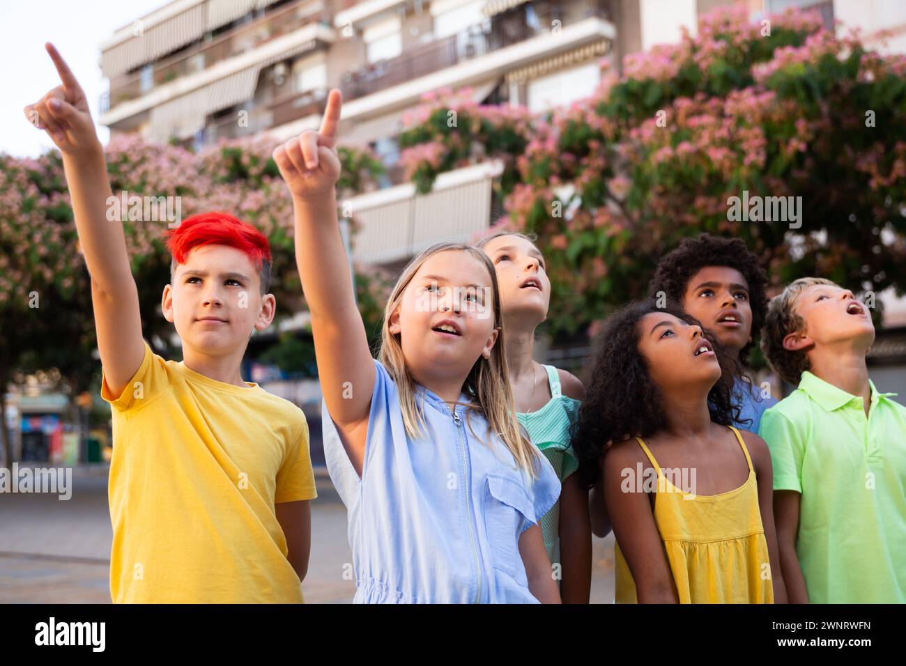 Interested multiracial children pointing fingers and looking up Stock ...