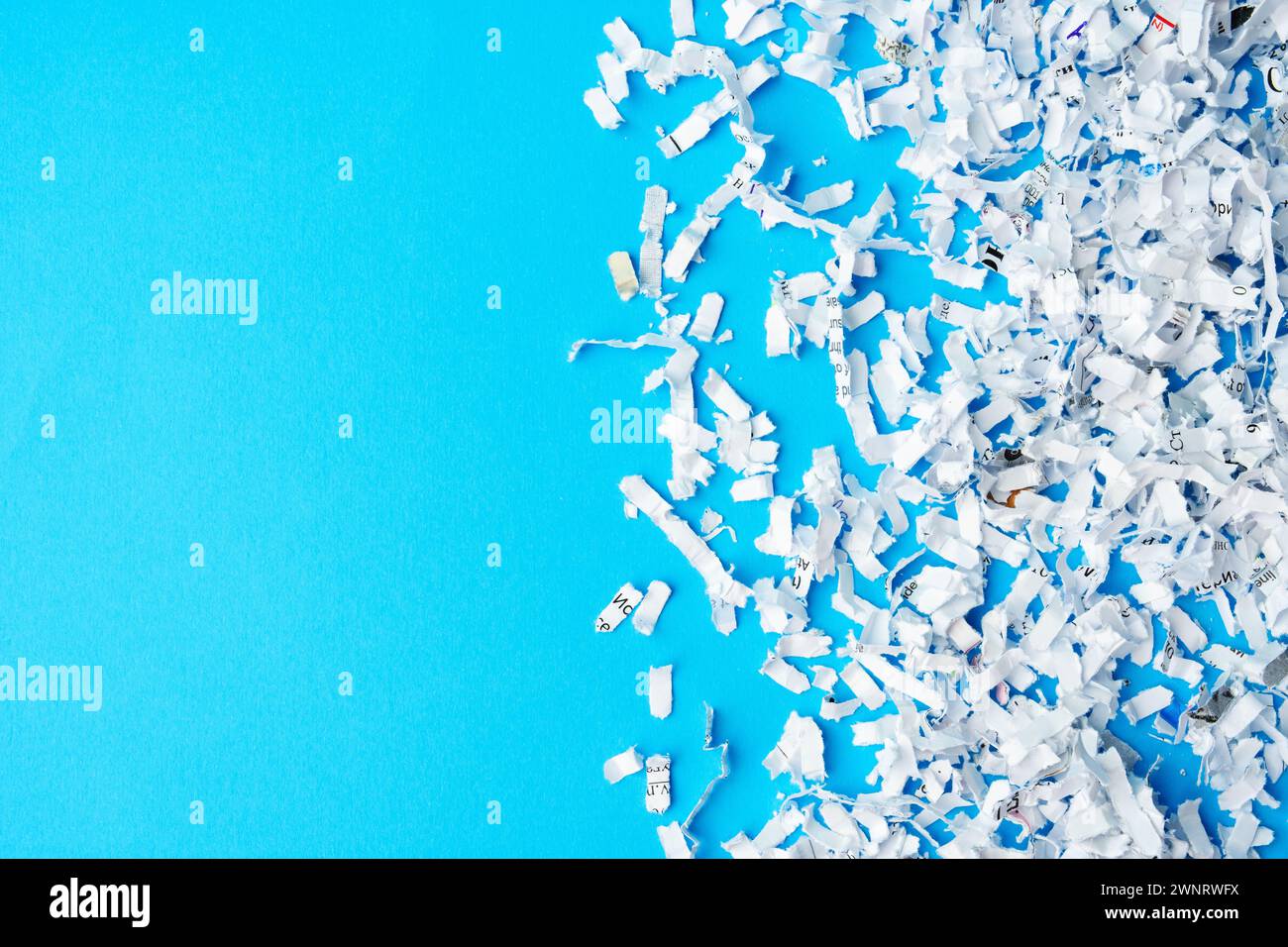 Shredded paper pieces on a blue background Stock Photo - Alamy