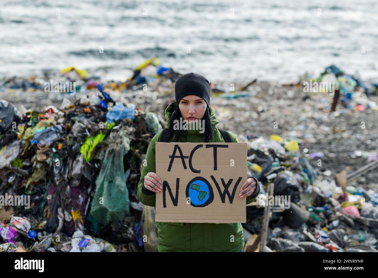 Activist holding placard, protest sign, standing on landfill, large ...