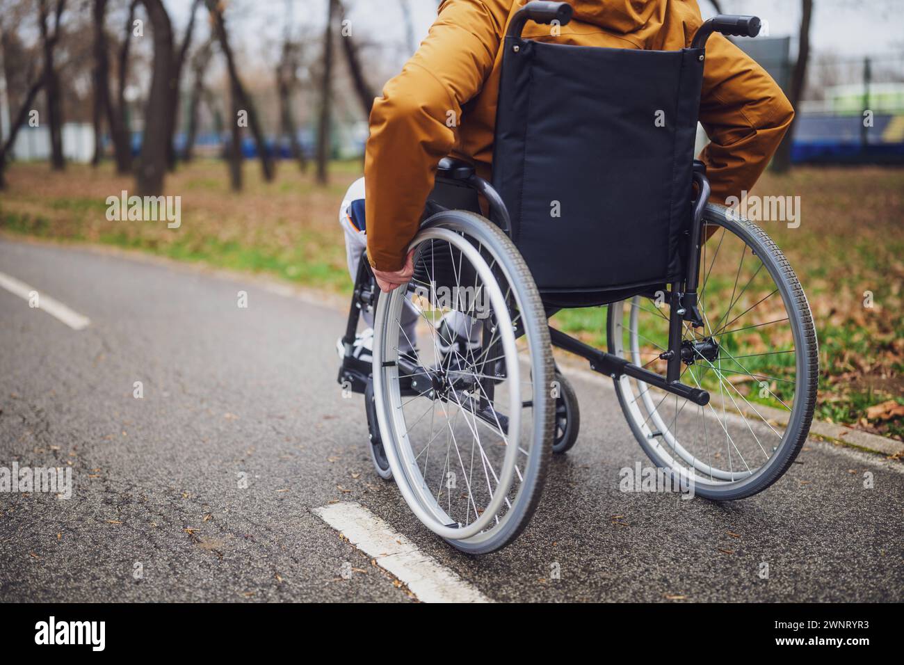 Close up image of paraplegic handicapped man in wheelchair in park. He ...