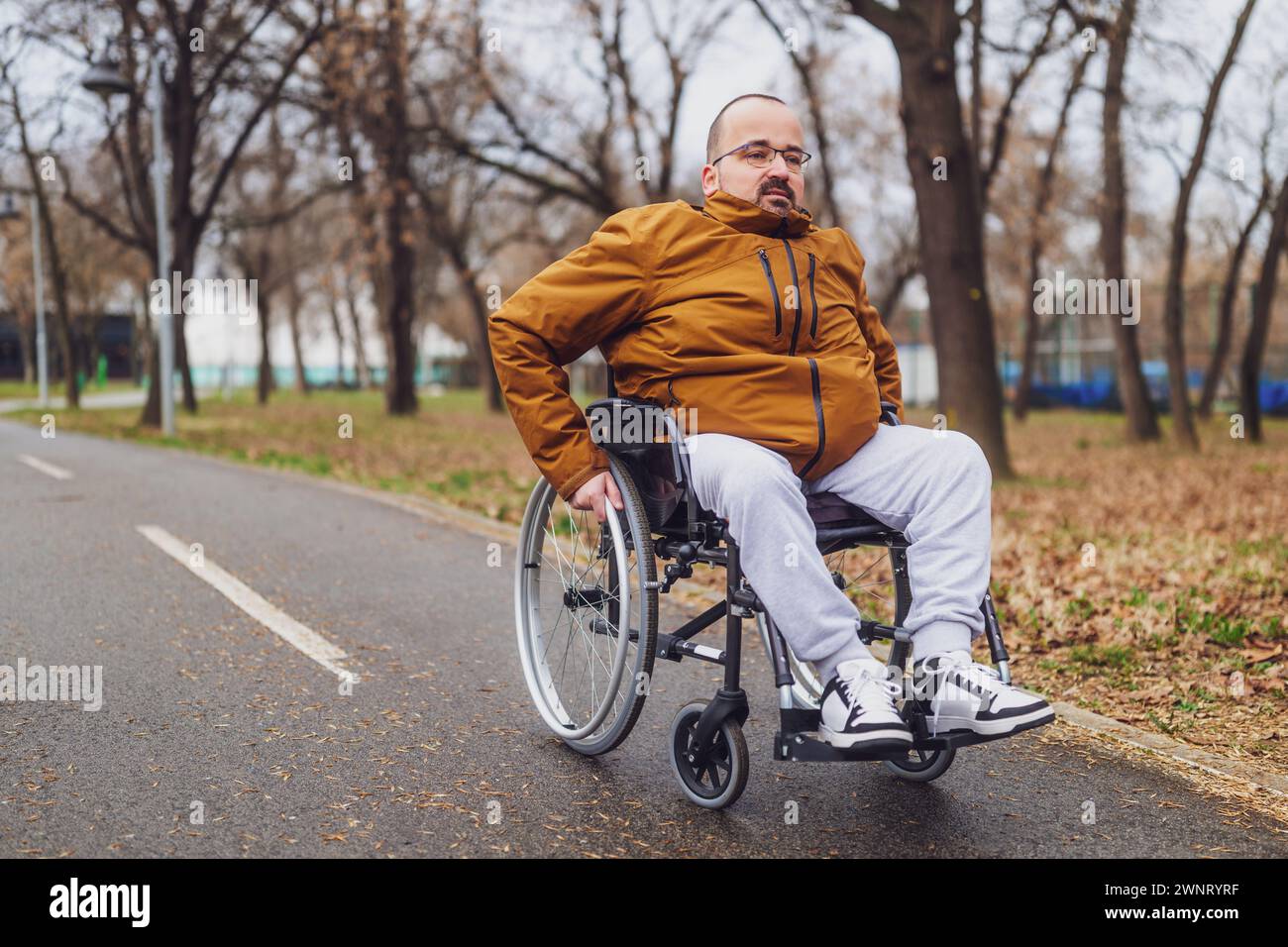 Portrait of paraplegic handicapped man in wheelchair in park. He is ...